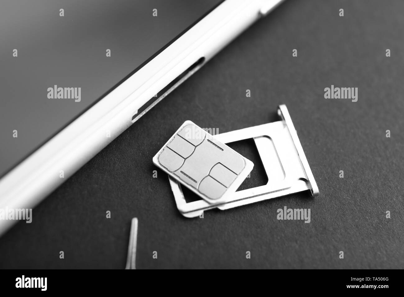Sim card with slot and mobile phone on dark background Stock Photo - Alamy