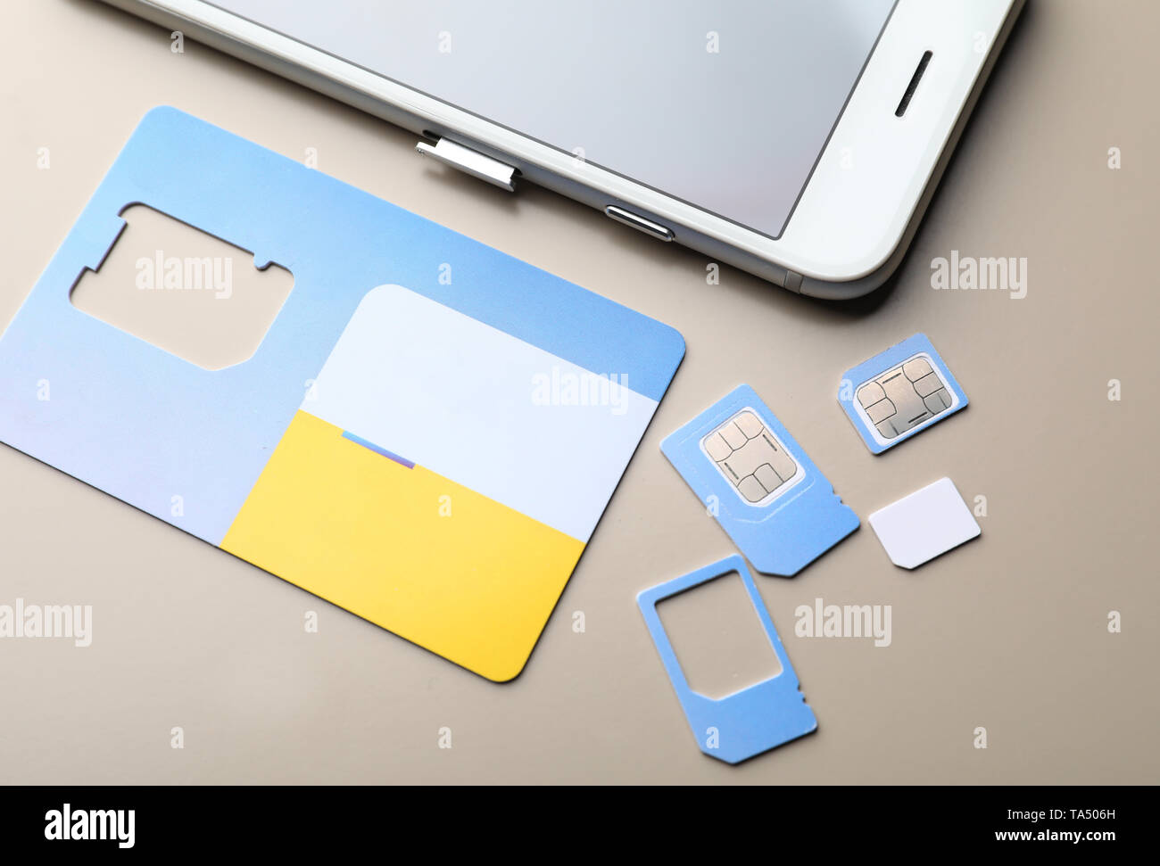 Sim cards with mobile phone on grey background Stock Photo - Alamy