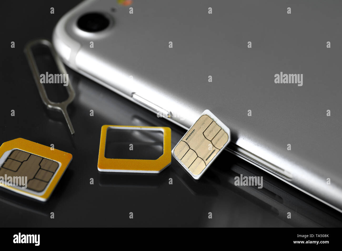 Mobile phone with sim cards and key on dark table Stock Photo - Alamy