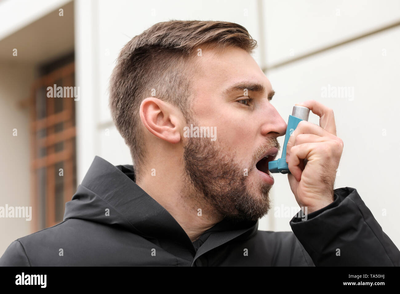 Young man with inhaler having asthma attack outdoors Stock Photo - Alamy