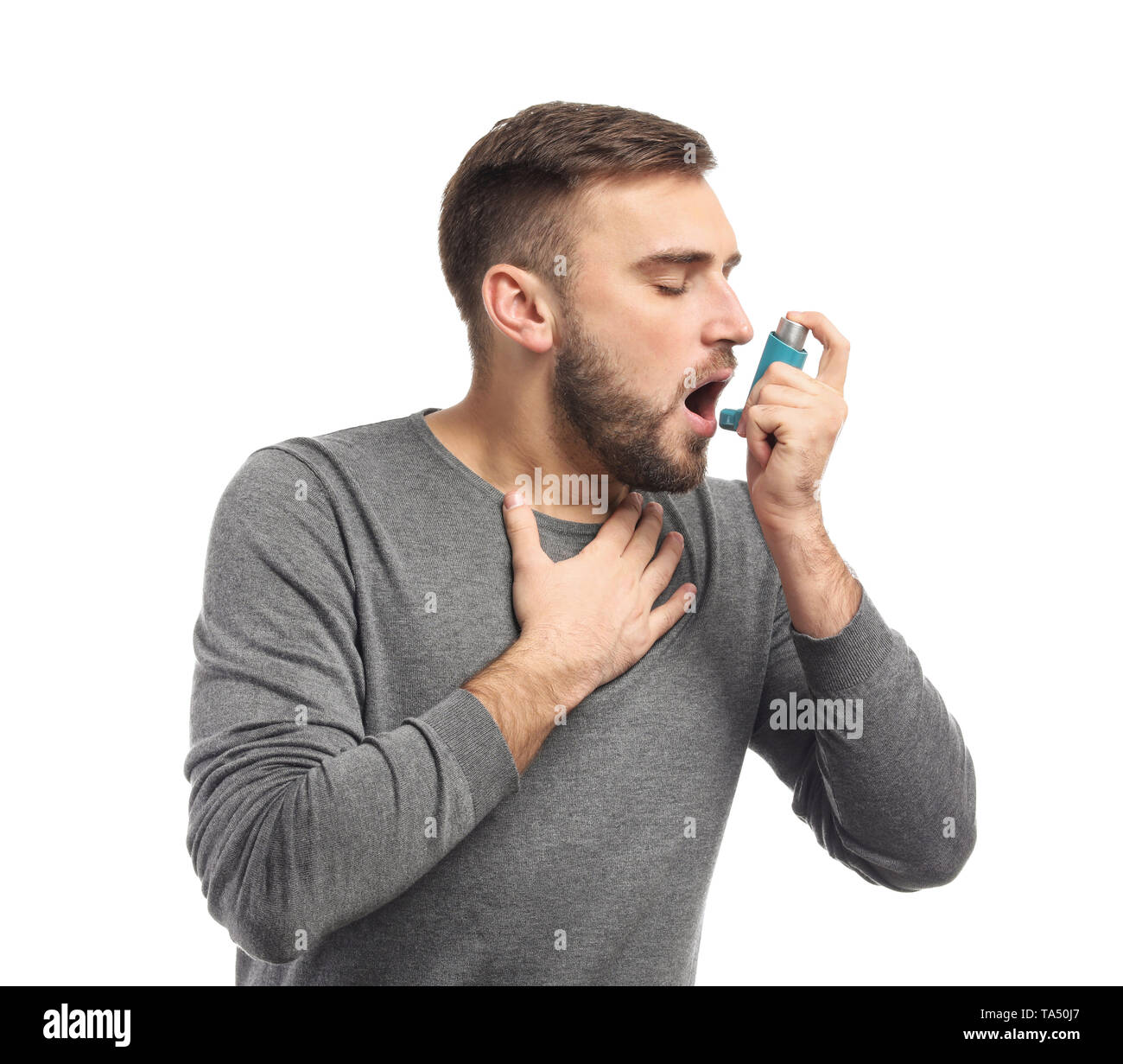 Young man with inhaler having asthma attack on white background Stock ...