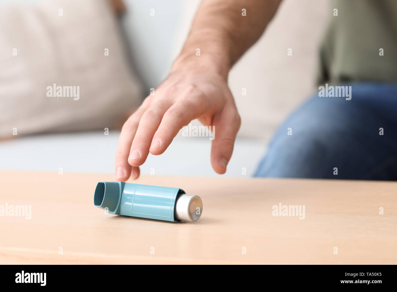 Young man with asthma attack taking inhaler from table, closeup Stock ...