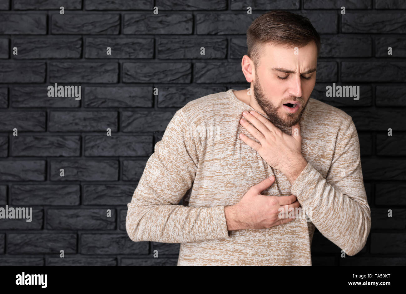 Young man having asthma attack on dark background Stock Photo - Alamy