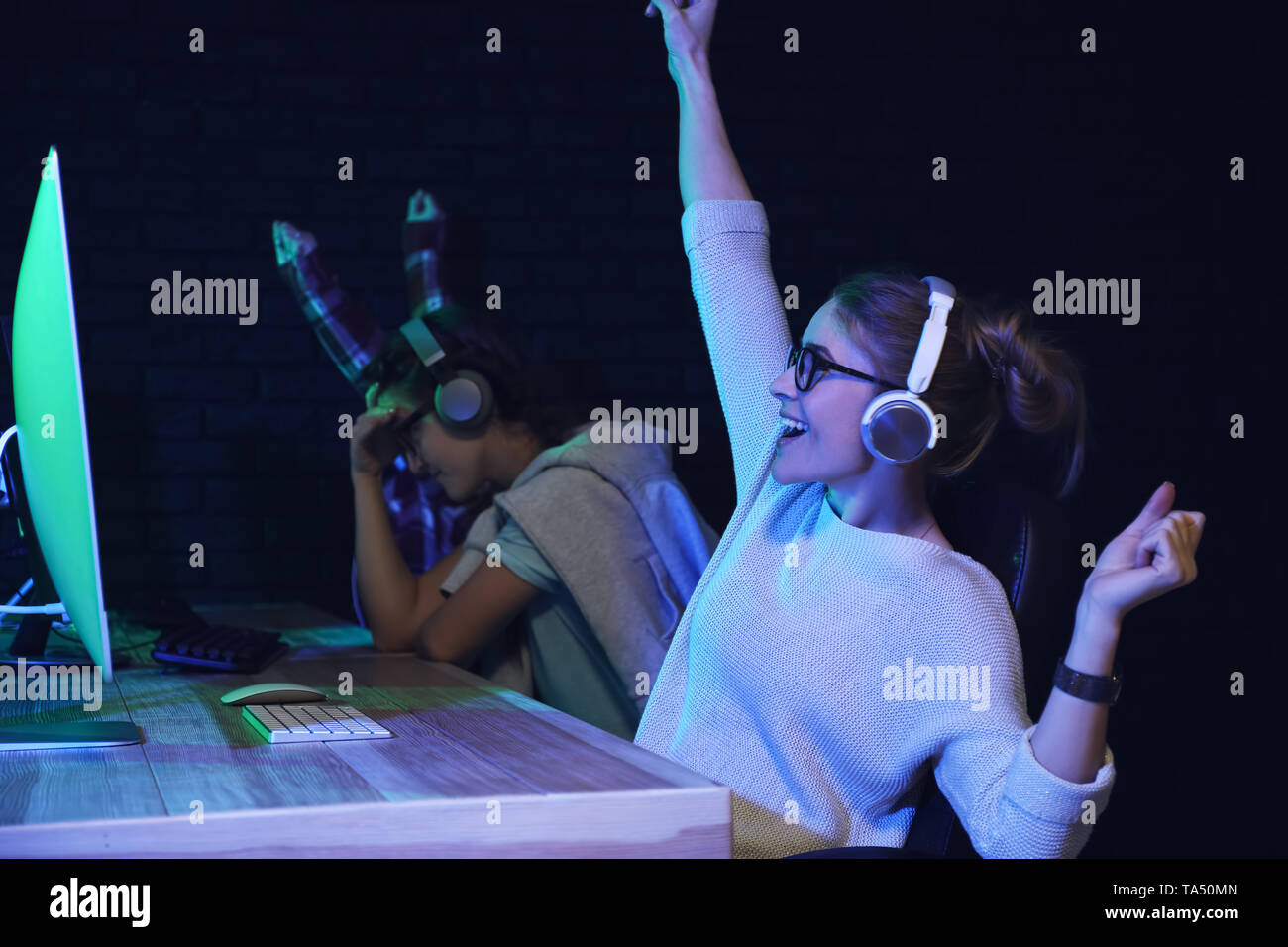 Happy young woman after winning computer game in club Stock Photo - Alamy