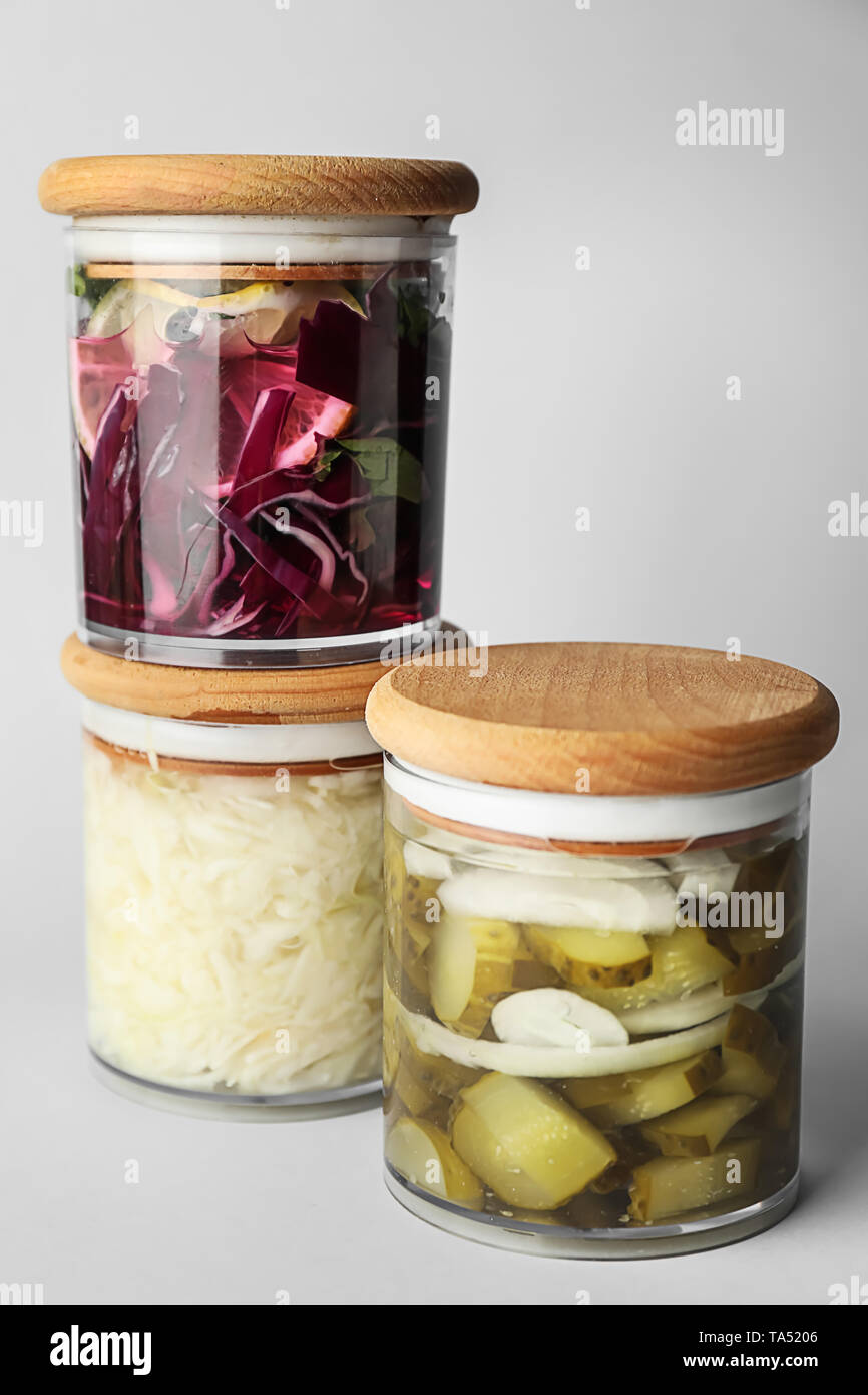 Glass jars with fermented vegetables on light background Stock Photo ...