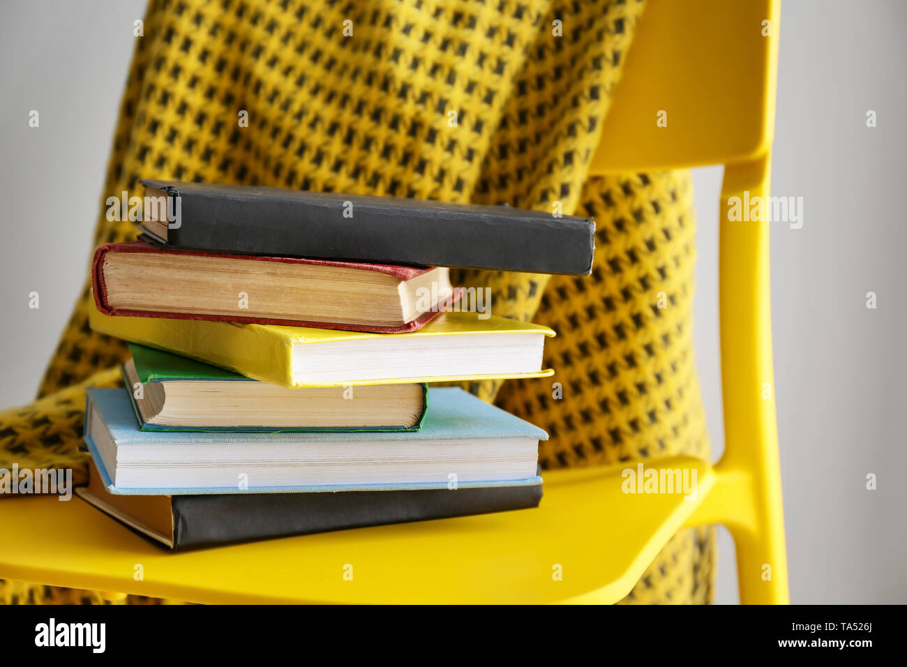 Stack of books on chair Stock Photo - Alamy