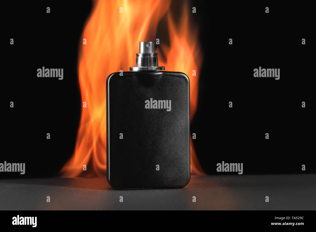 Bottle of perfume and burning flame on dark background Stock Photo - Alamy