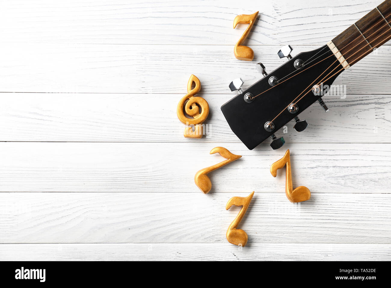 Guitar and music notes on white wooden background Stock Photo - Alamy