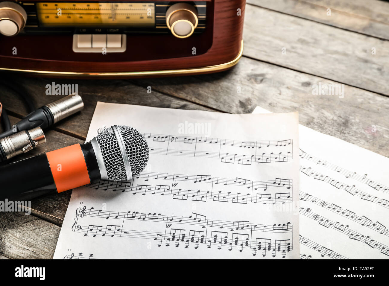Microphone and music sheets on wooden table Stock Photo - Alamy