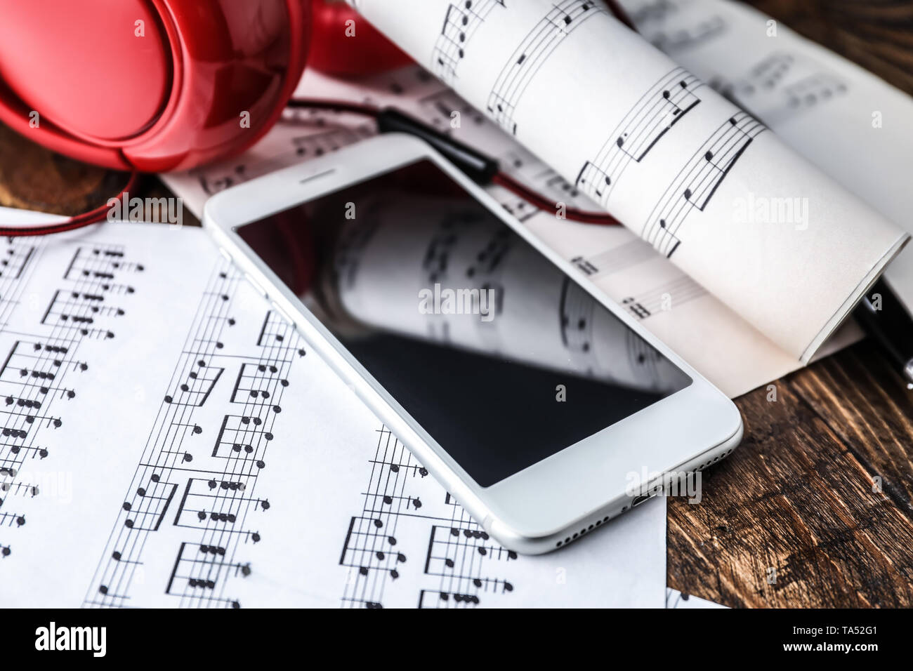 Mobile phone, headphones and music sheets on table Stock Photo - Alamy