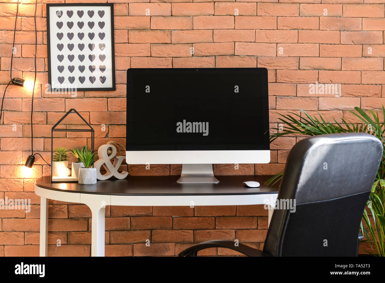 Stylish workplace with modern computer near brick wall Stock Photo - Alamy