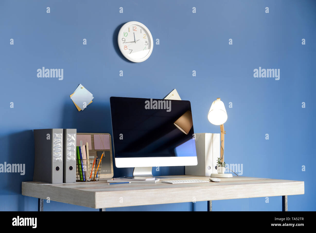 Stylish workplace with modern computer near color wall Stock Photo - Alamy