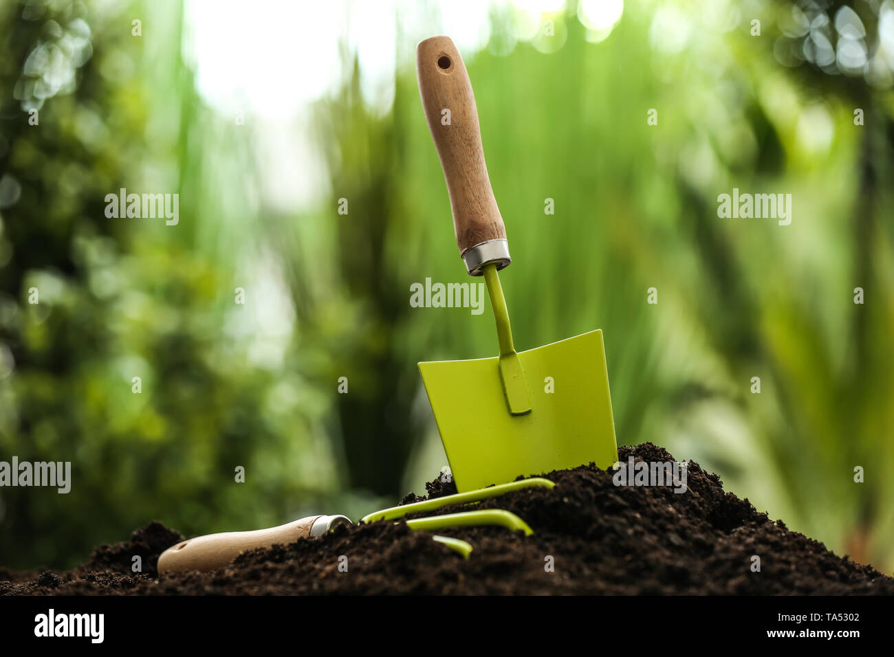 Gardening tools with heap of soil outdoors Stock Photo - Alamy