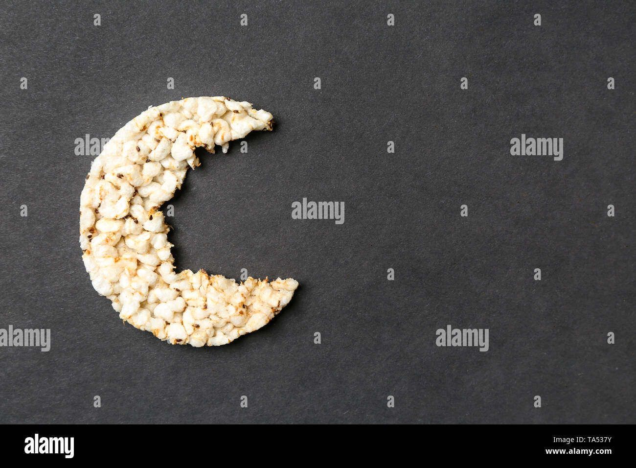 Half-moon made of bitten crisp bread as symbol of Islam on dark ...