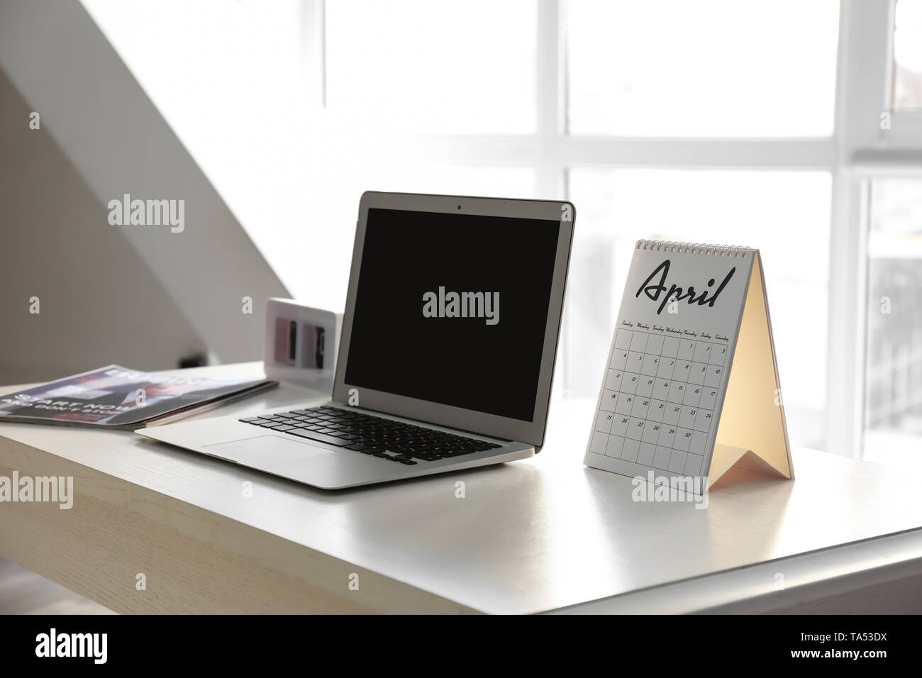 Flip calendar with laptop on table in office Stock Photo - Alamy