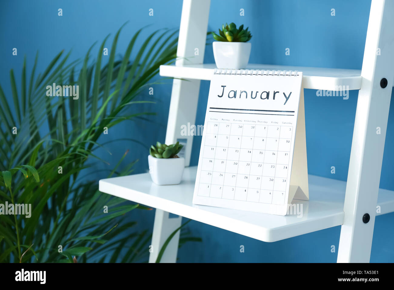Flip calendar on white shelf in room Stock Photo - Alamy