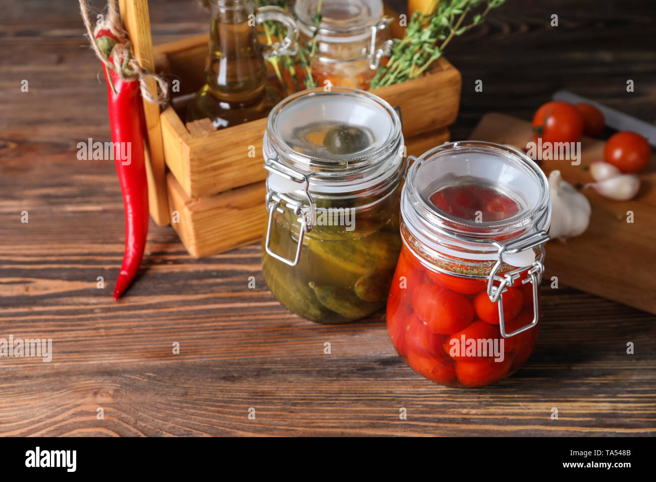 Jars with tasty fermented vegetables on wooden table Stock Photo - Alamy