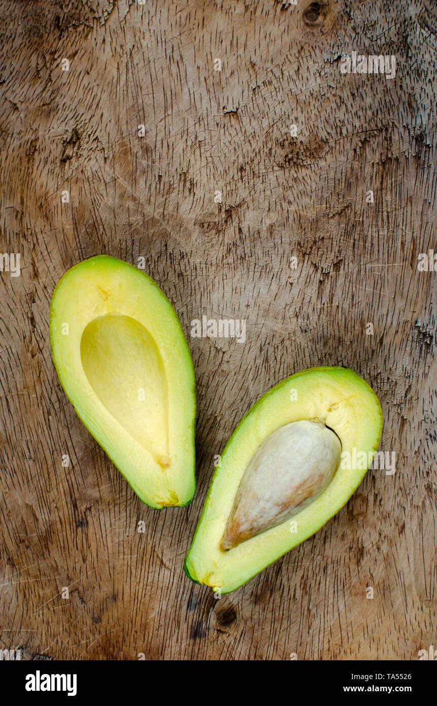 Halved avocado on a rustic cutting board Stock Photo - Alamy