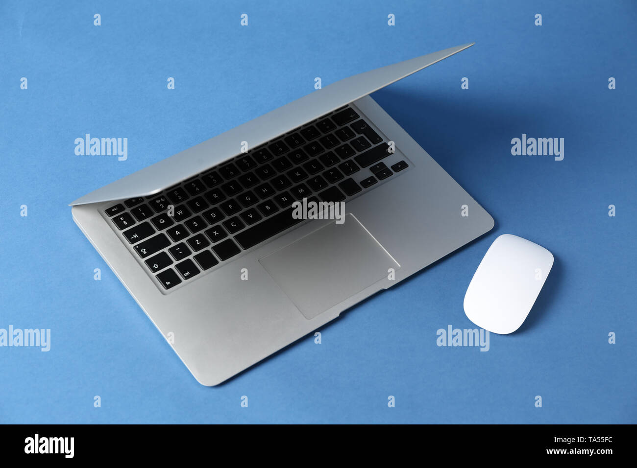Modern laptop and PC mouse on color background Stock Photo - Alamy