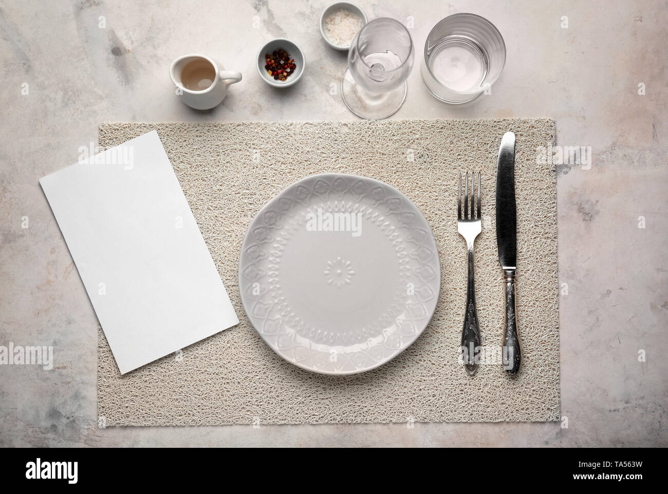 Simple table setting on grey background Stock Photo - Alamy