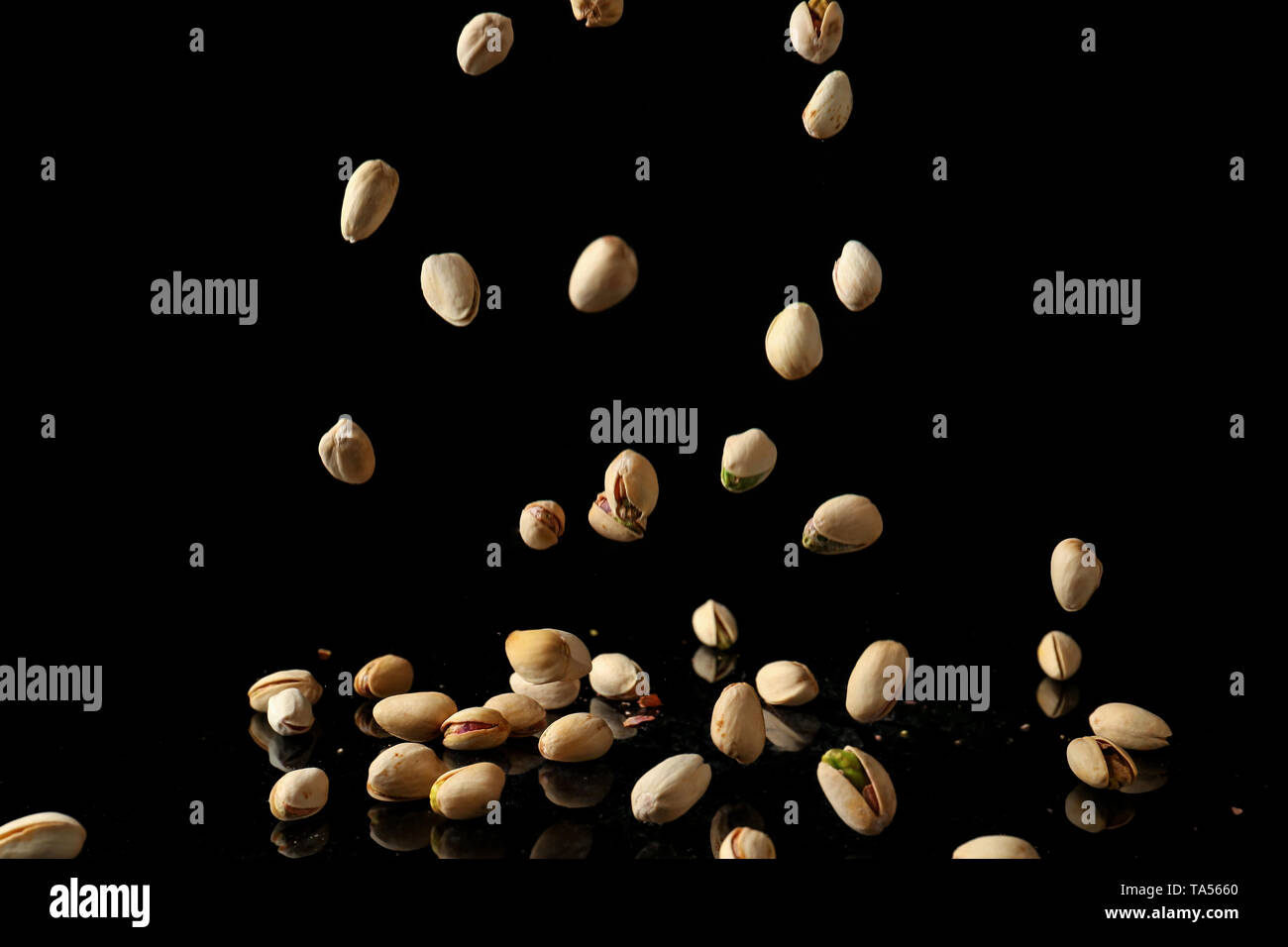 Falling pistachio nuts on dark background Stock Photo - Alamy
