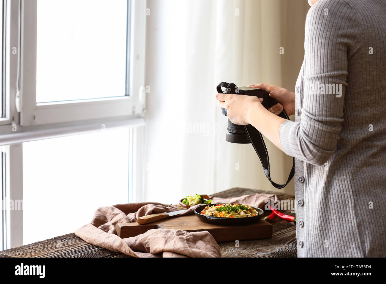 Young woman taking picture of food in professional studio Stock Photo ...