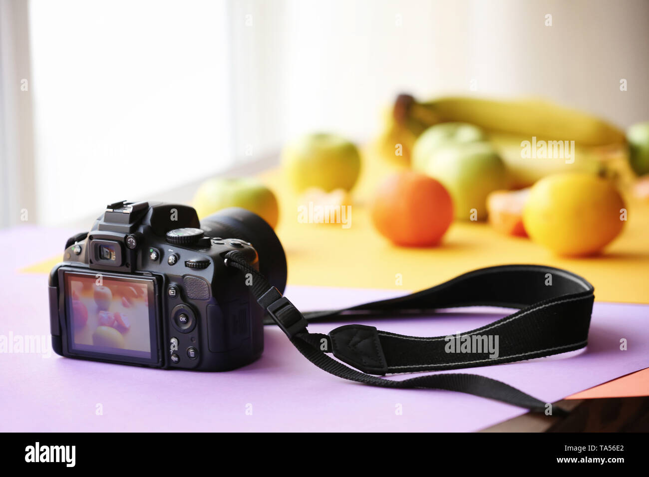 Professional photo camera near composition of fruits on table in studio ...