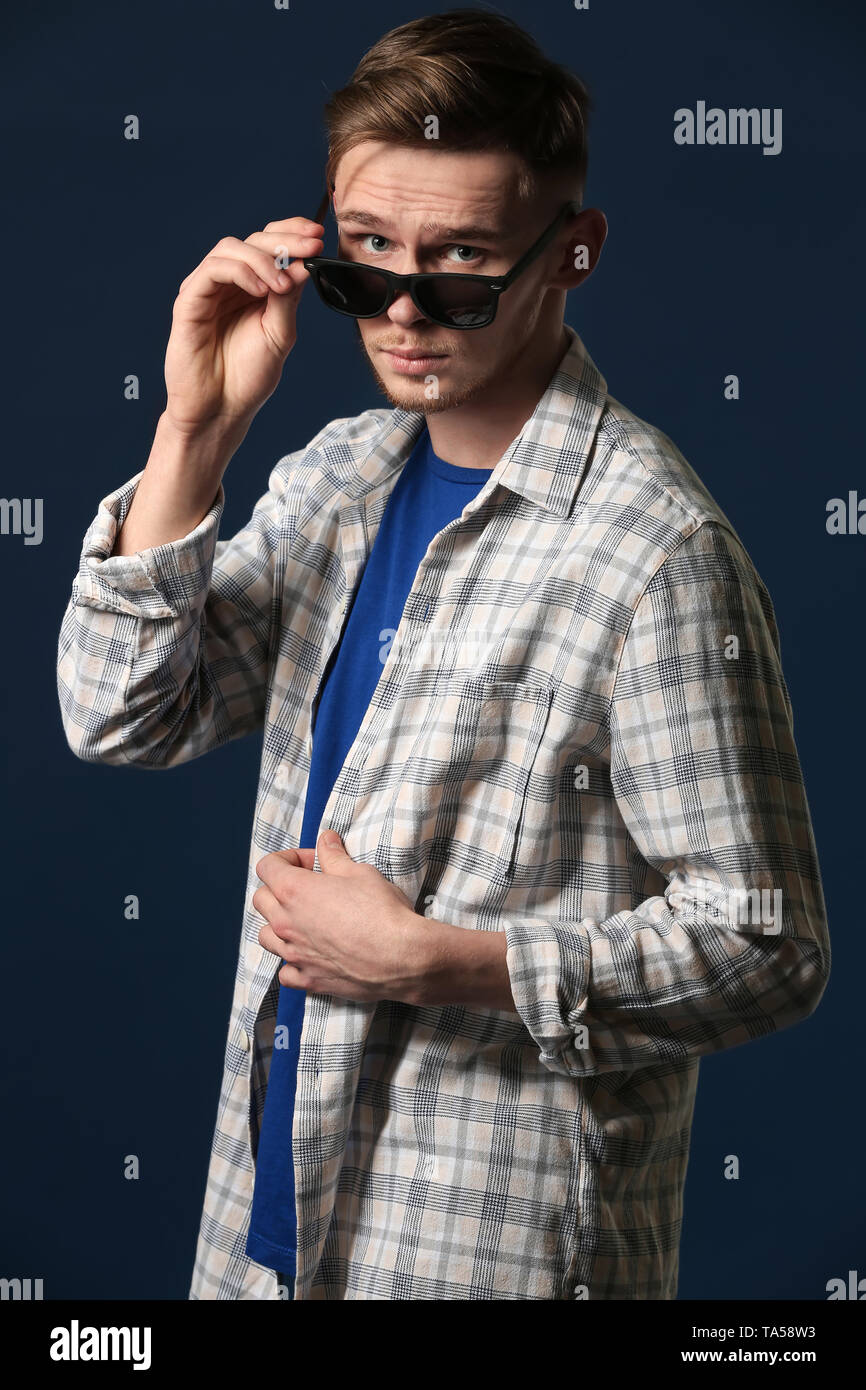 Portrait of handsome stylish young man on color background Stock Photo ...
