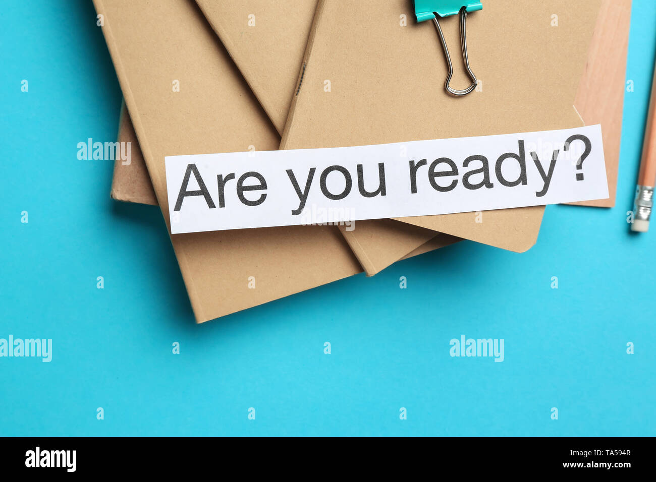 Notebooks and paper with text ARE YOU READY? on color background ...