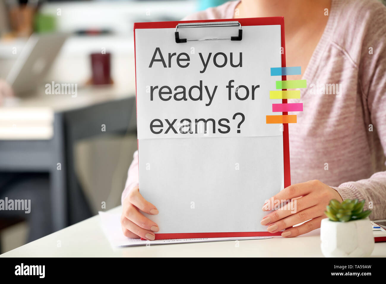 Girl holding clipboard with text ARE YOU READY FOR EXAMS? in classroom ...