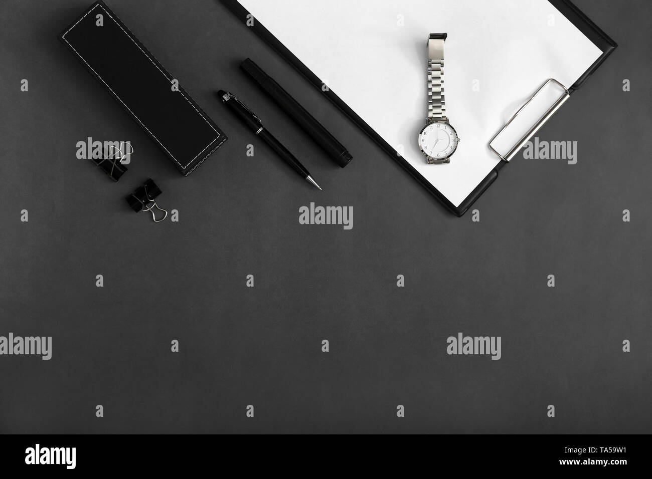 Stylish stationery with watch on dark background Stock Photo - Alamy