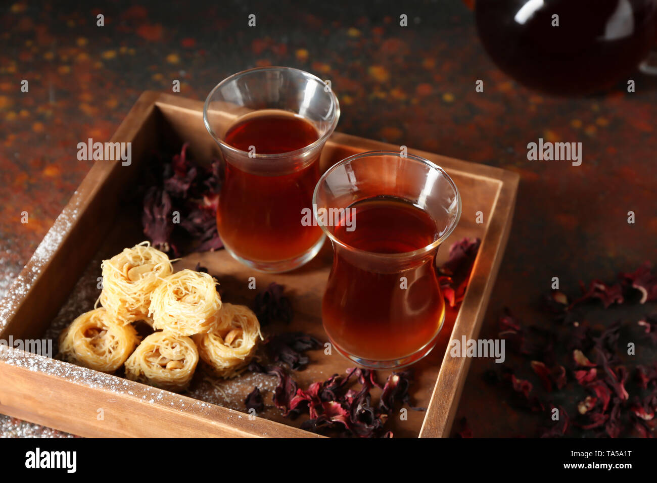 Wooden tray with Turkish tea in traditional glasses and East sweets on ...