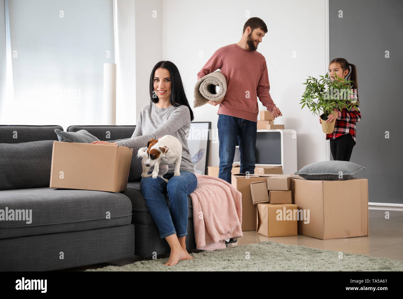 Family unpacking things after moving into new house Stock Photo - Alamy