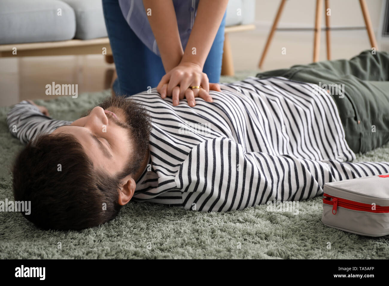 Woman providing first aid to her unconscious husband at home Stock ...