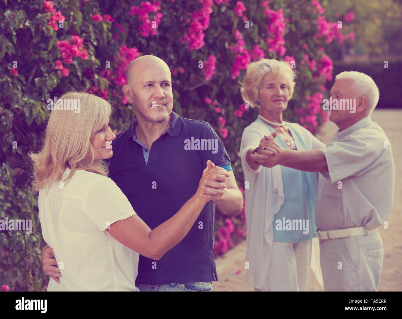 Happy aged parents with adult children dancing in summer garden Stock ...
