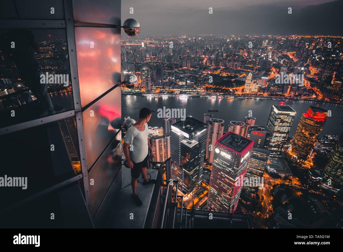 Extreme photography with the photograph standing on one of the tallest ...