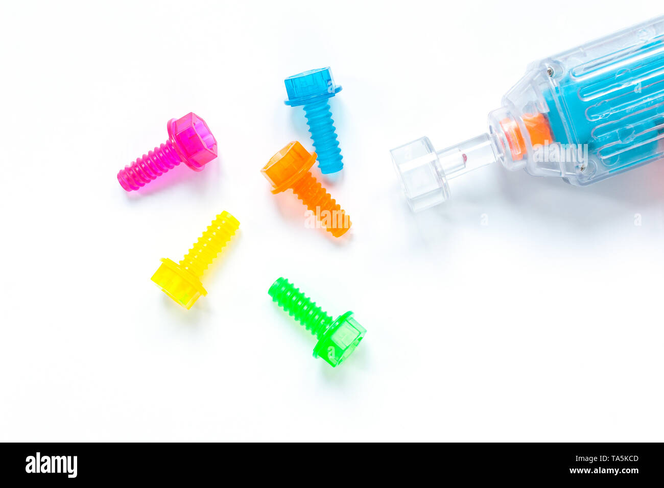 Colored neon translucent plastic toy bolts and screwdriver on white ...