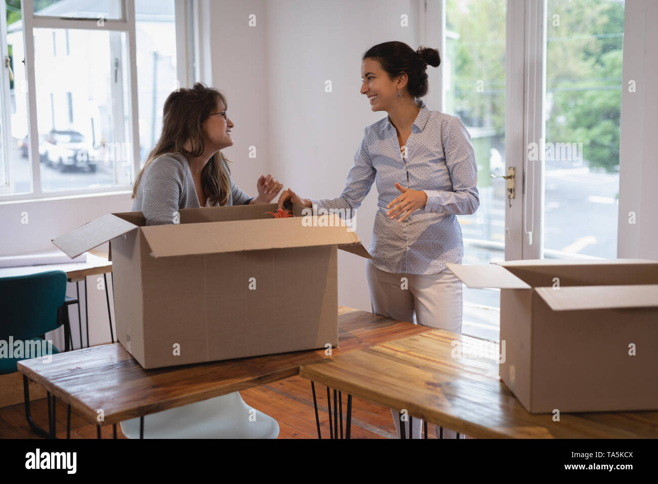 Businesswomen packing cardboard boxes in the office Stock Photo - Alamy