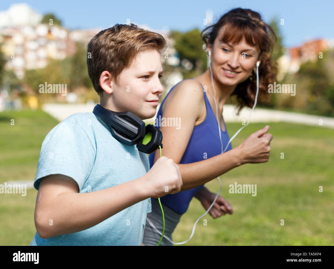Active family of young mother and tweenage son running together on ...