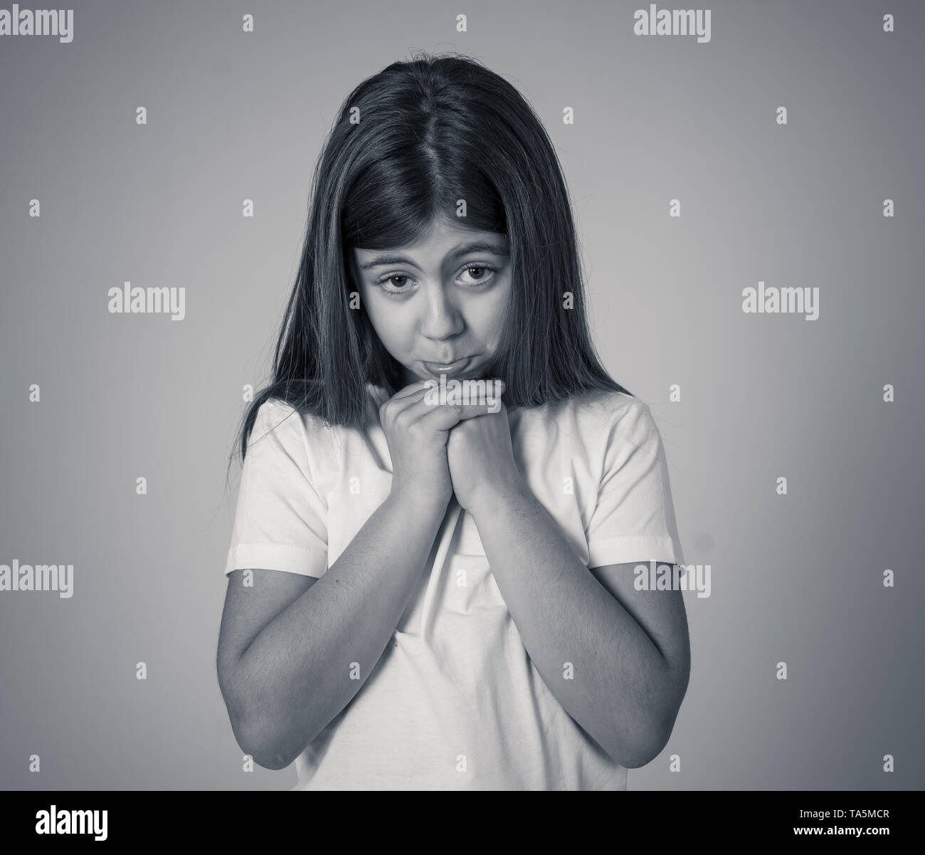 Portrait of a pretty young child looking unhappy and sad making funny ...