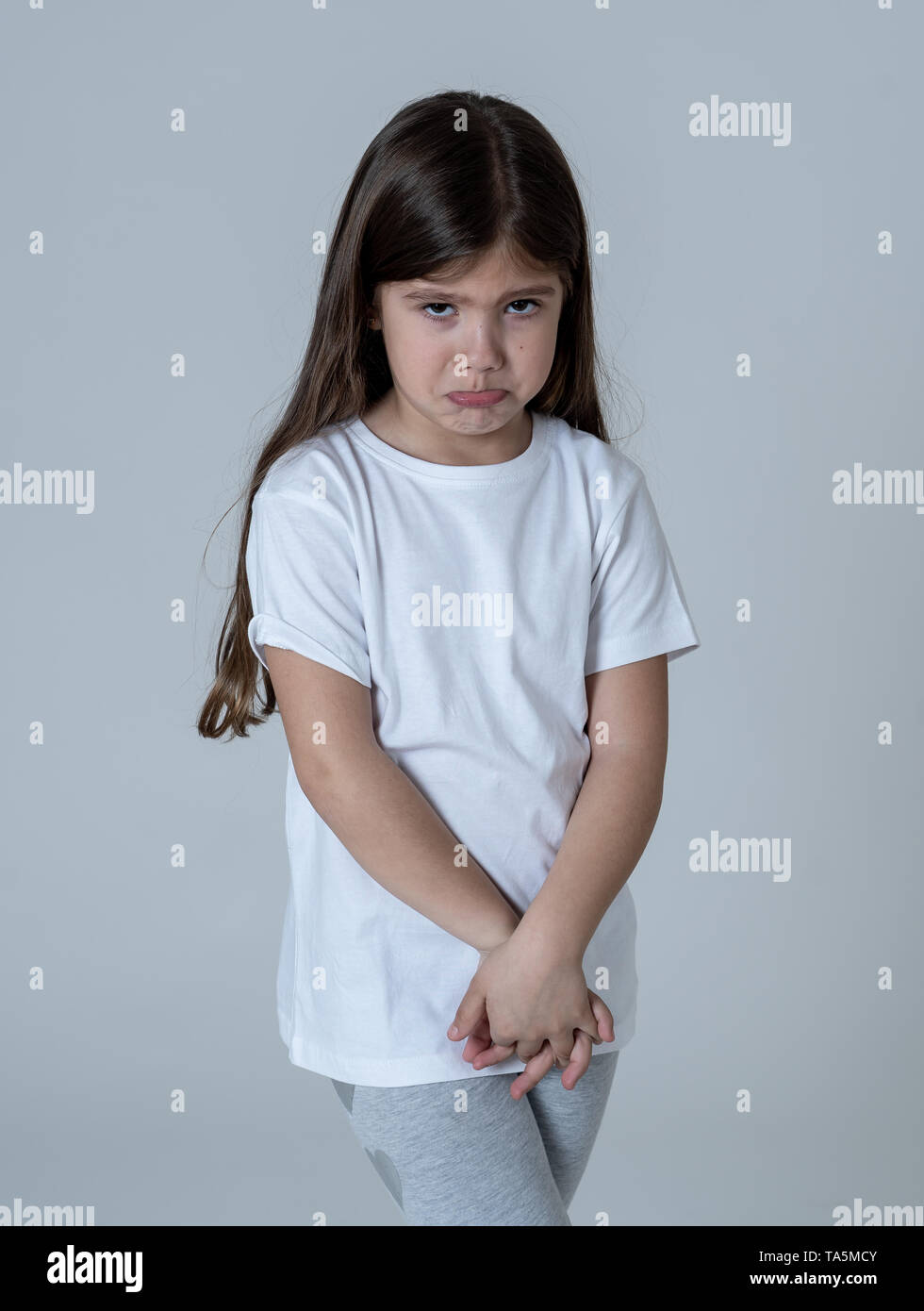 Portrait of a pretty young child looking unhappy and sad making funny ...