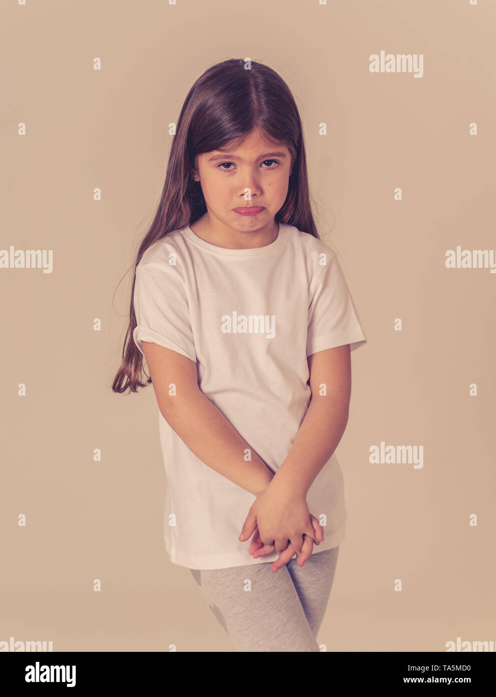 Portrait of a pretty young child looking unhappy and sad making funny ...