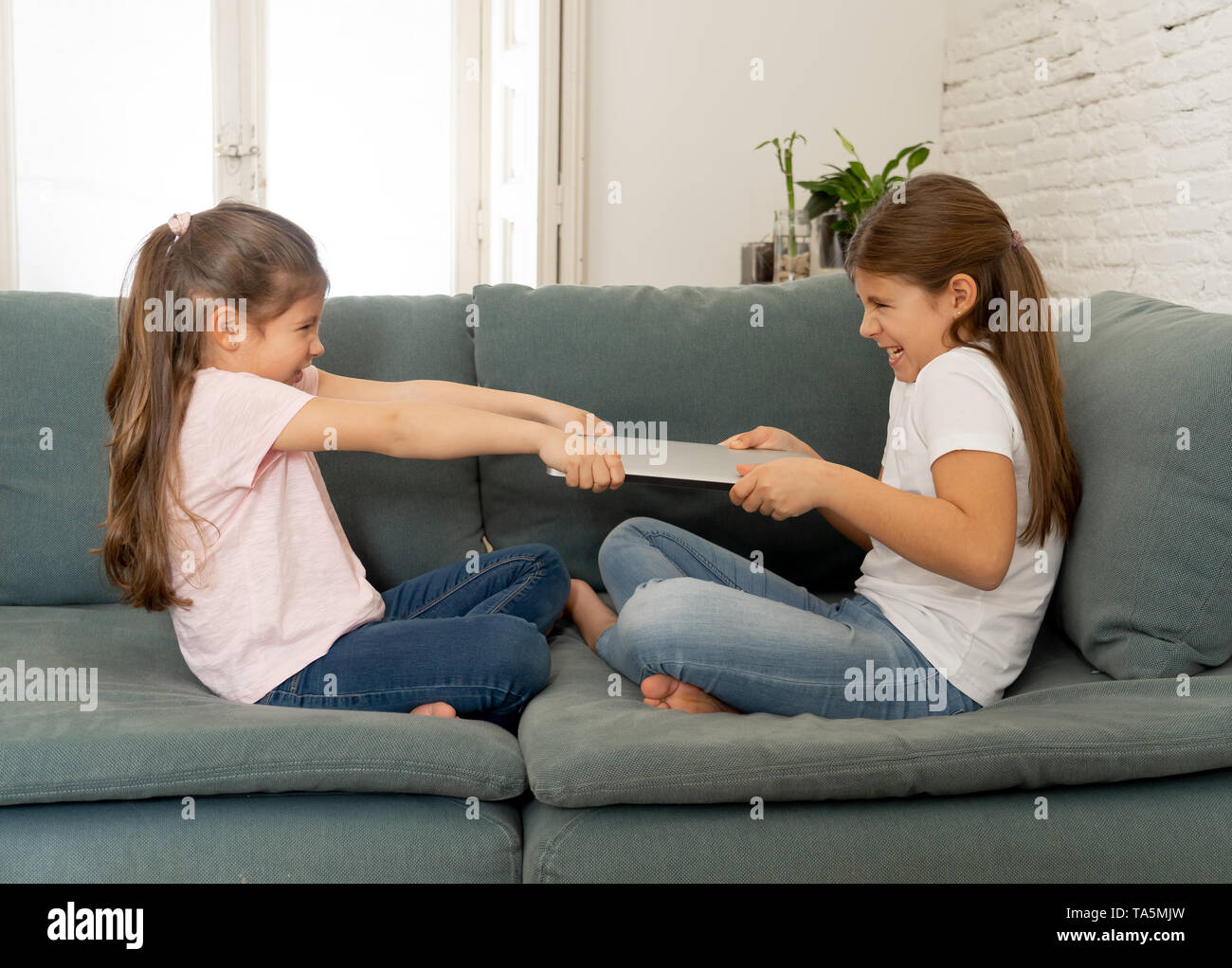 Younger and older girls fighting for laptop arguing over playing on the ...