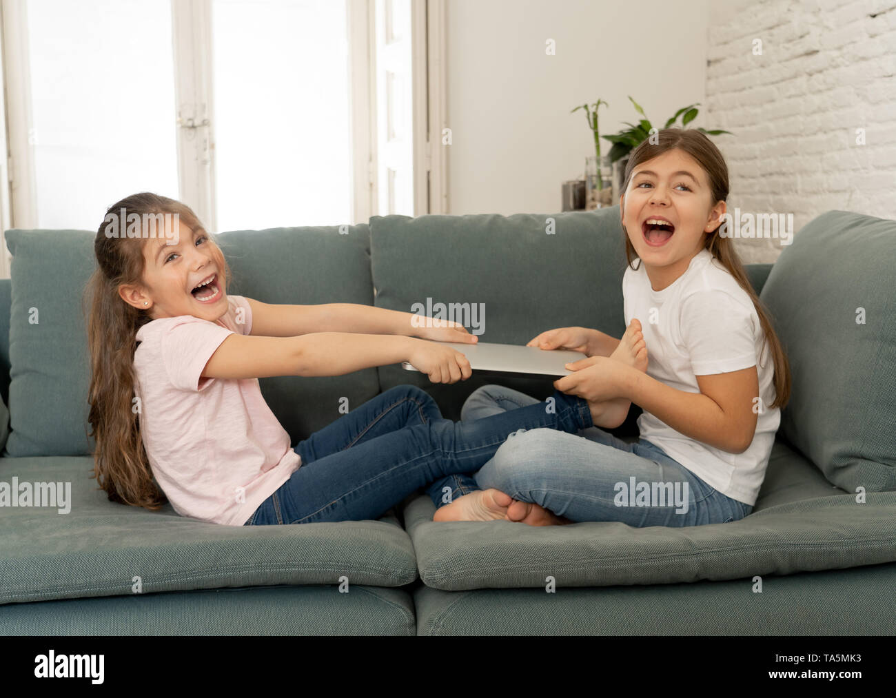 Younger and older girls fighting for laptop arguing over playing on the ...