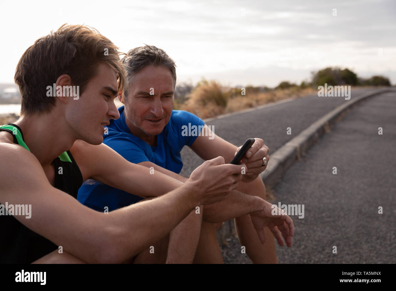 Father and son looking at mobile phone Stock Photo - Alamy