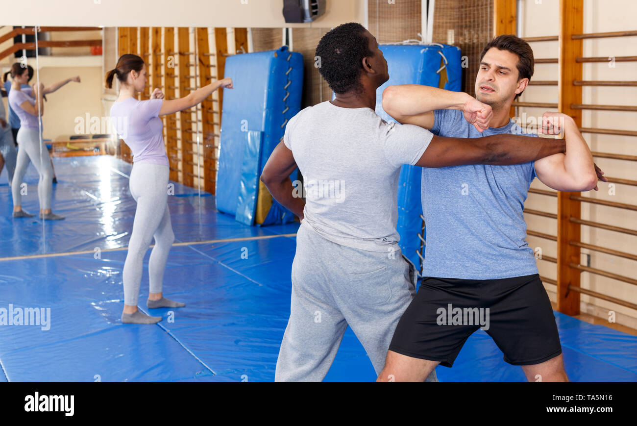 Males training attack movements in pair at self protection workout ...