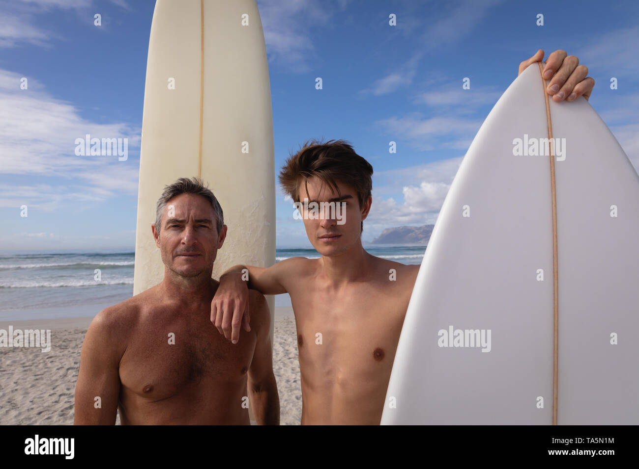 Father and son standing with surfboard Stock Photo - Alamy