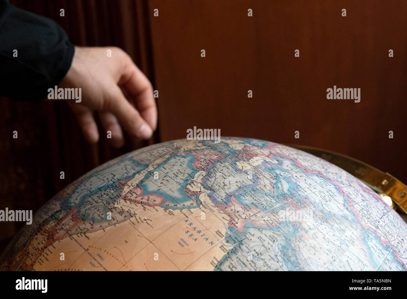 Hand touching earth globe detail Stock Photo - Alamy