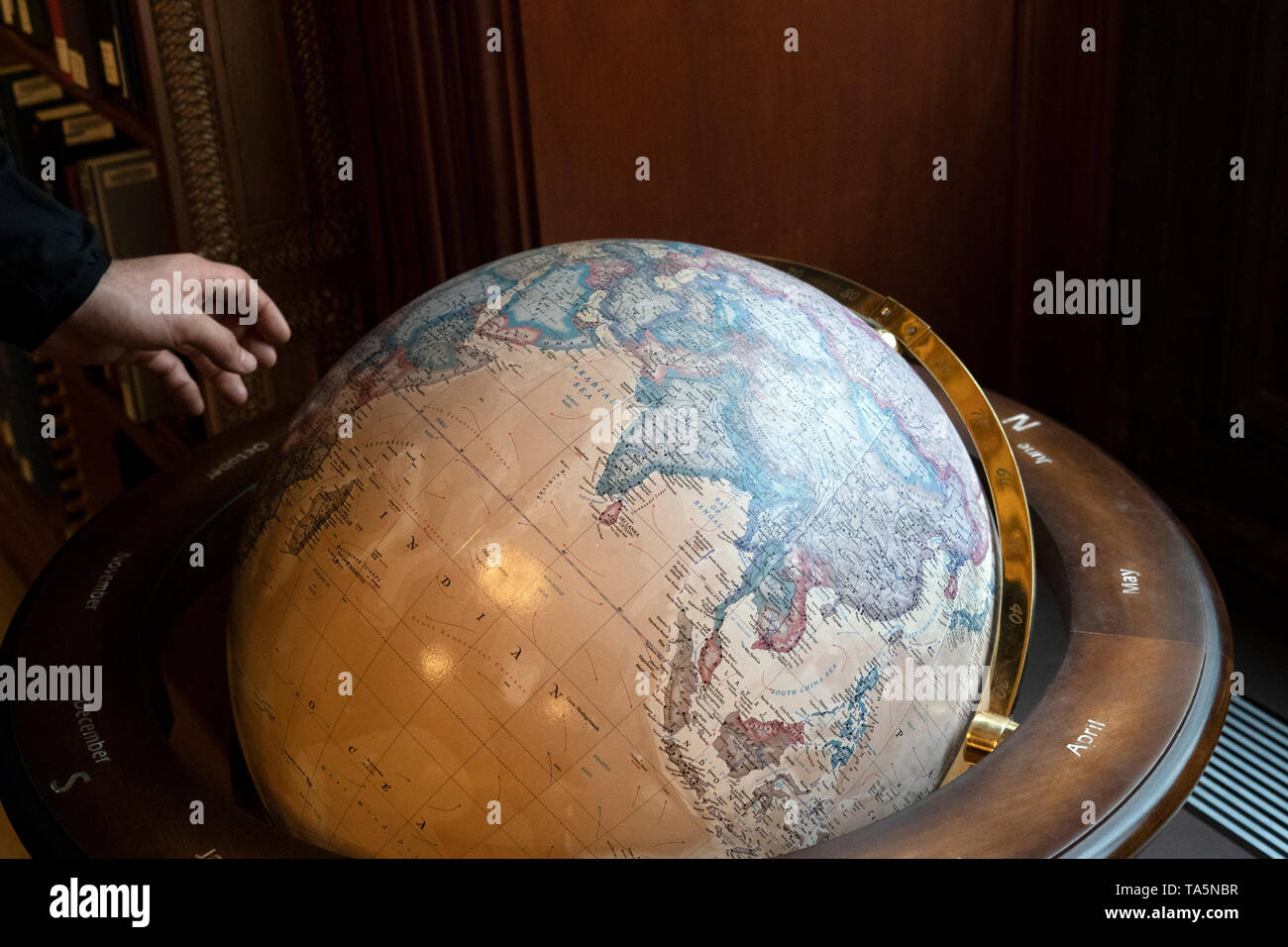 Hand touching earth globe detail Stock Photo - Alamy