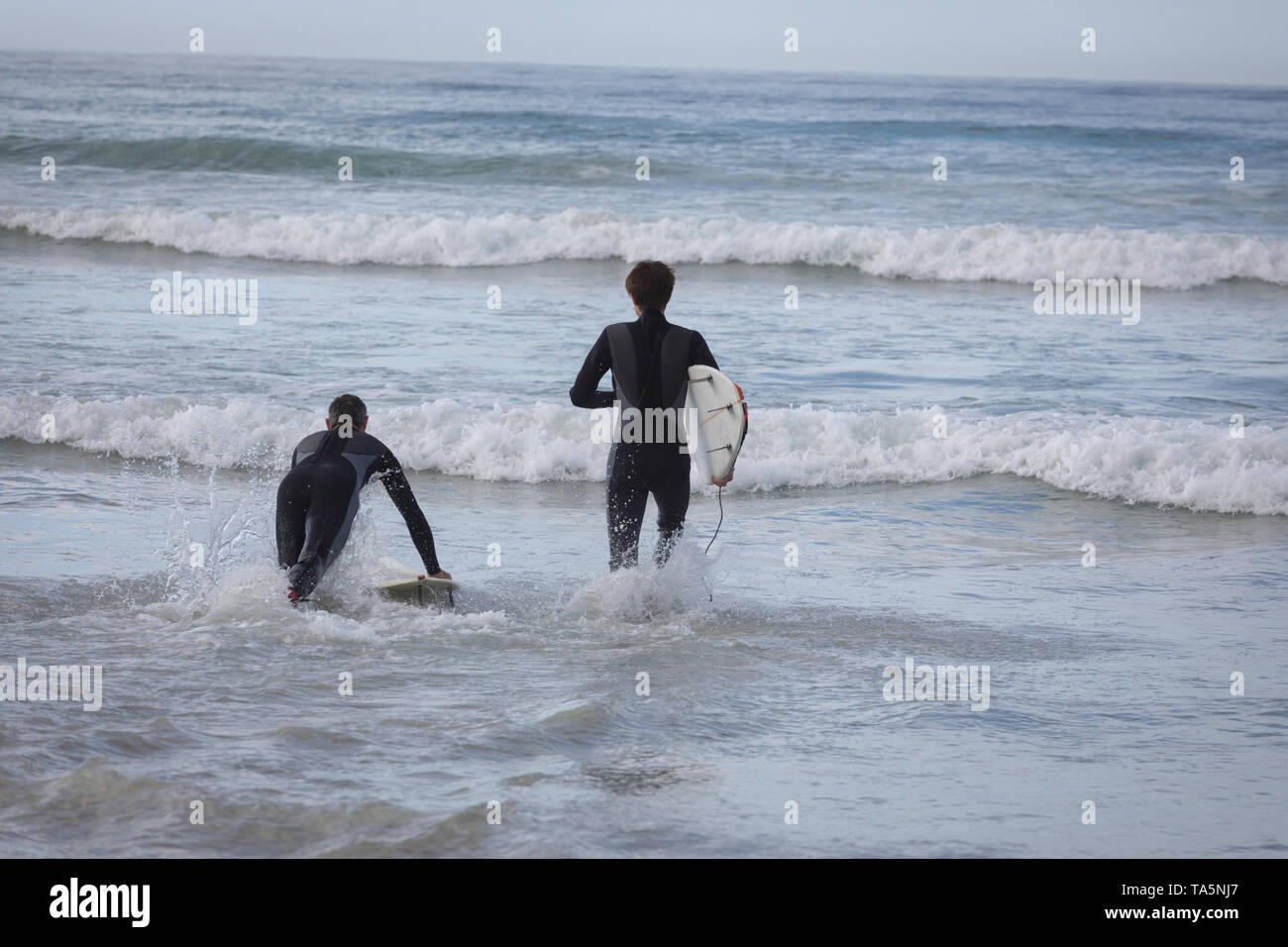Father and son surfing with surfboard in sea Stock Photo - Alamy
